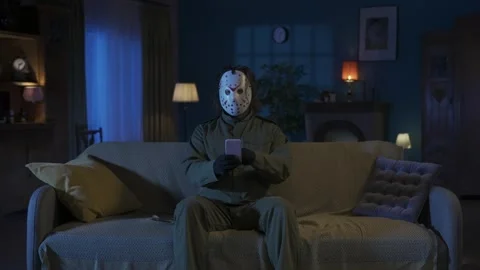 Horror maniac sitting on the sofa in the... | Stock Video | Pond5