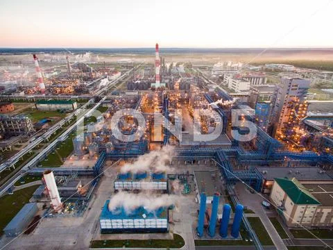 Photograph: A huge oil refinery with metal structures, pipes and ...