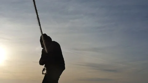 human in black hoodie pulling rope on wi... | Stock Video | Pond5