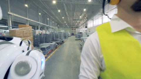 Human factory worker and a robot are wal... | Stock Video | Pond5