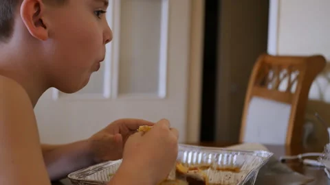 a hungry teen boy eats a cake holding a ... | Stock Video | Pond5