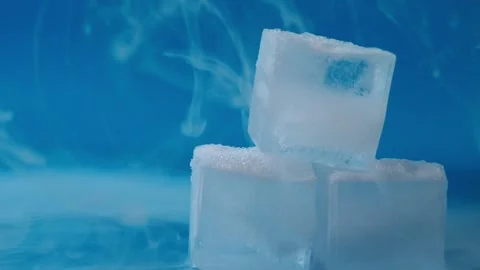 Ice cubes with dry ice chilling on blue ... | Stock Video | Pond5