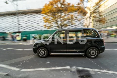 An Iconic English Cab driving fast on the road in London, England ...