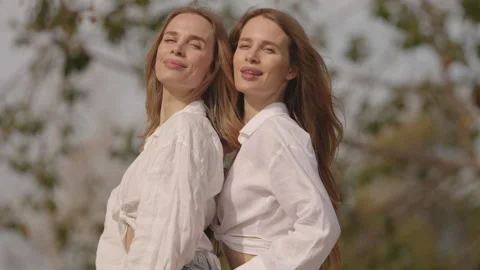 Identical twins posing in a park | Stock Video | Pond5