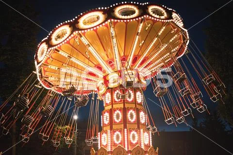 Illuminated swing chain carousel in amusement park at the night Stock ...