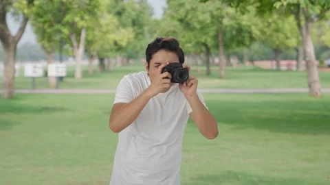 Indian man clicking photos using camera | Stock Video | Pond5