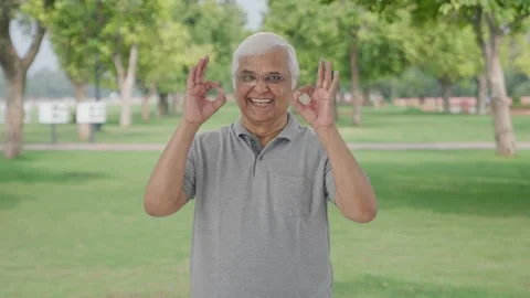 Indian old man showing okay sign in park | Stock Video | Pond5