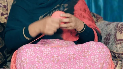 Indian woman rolling the red thread into... | Stock Video | Pond5