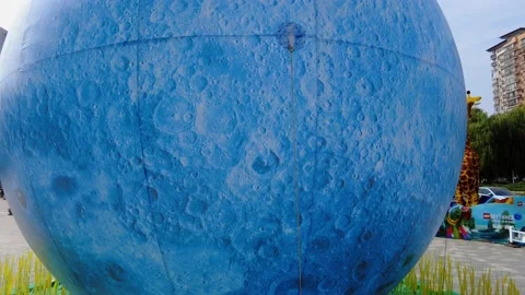 Inflated moon reverse dolly view on bea... | Stock Video | Pond5