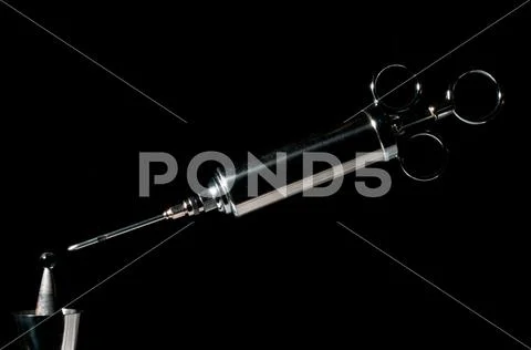 Inox steel syringe isolated in black background with crystal ball and ...