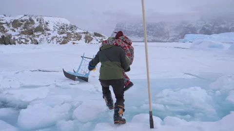 Inuit father carrying daughter over melt... | Stock Video | Pond5