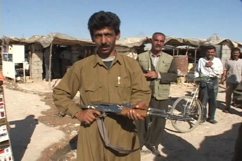 An Iraqi man poses with his rifle but sm... | Stock Video | Pond5