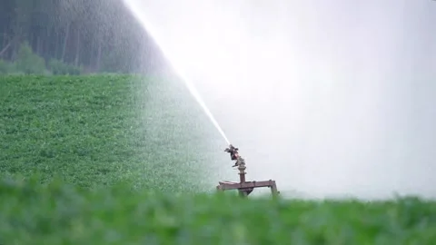Irigation Sprinklers water a Dry Field D... | Stock Video | Pond5