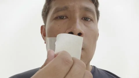 Irritated Thai man pull off a tape over ... | Stock Video | Pond5