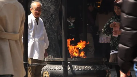 Japanese priest using stick to stoke fir... | Stock Video | Pond5