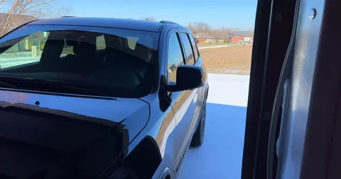 Jeep backing out of garage onto snow and... | Stock Video | Pond5