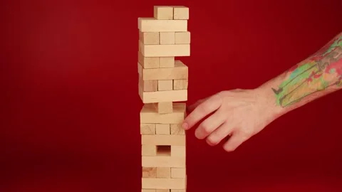 Jenga game on red background. Human hand... | Stock Video | Pond5