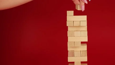 Jenga game on red background. Human hand... | Stock Video | Pond5