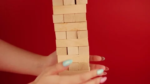 Jenga game on red background. Woman's ha... | Stock Video | Pond5