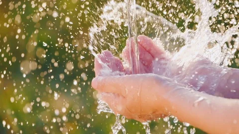 A jet of water splashes on human palms. ... | Stock Video | Pond5
