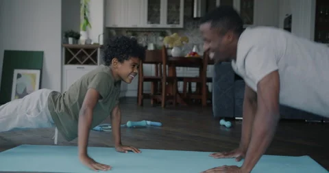 Joyful little boy doing push-ups with fa... | Stock Video | Pond5
