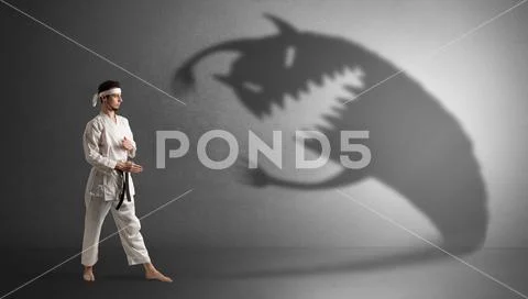 Karate man fighting with a big scary shadow Stock Image #95610731