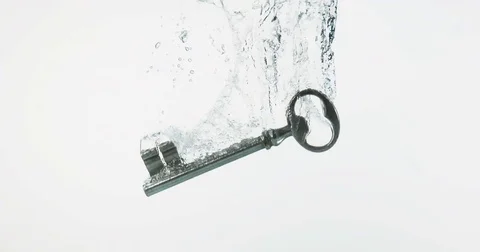 Key falling into Water agaisnt White Bac... | Stock Video | Pond5