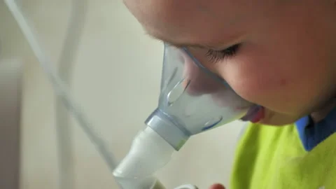 The kid is breathing with an inhaler and... | Stock Video | Pond5