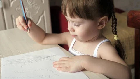 kid draws on sheet of white paper. Cute ... | Stock Video | Pond5