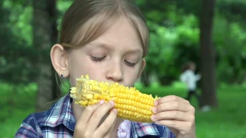 Kid Eating Boiled Corn Outdoor in Park, ... | Stock Video | Pond5
