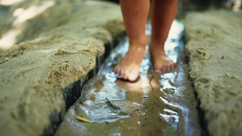 Kid feet stepping in wet muddy sand bare... | Stock Video | Pond5
