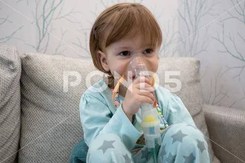 Kid girl makes inhalation with a nebulizer. sick child holding ...
