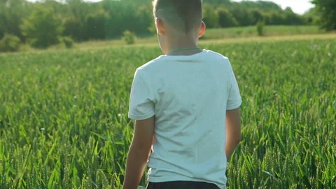 A kid with his back is walking across wh... | Stock Video | Pond5
