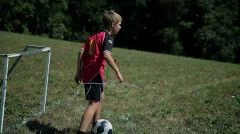 Kid leading a football and falling into ... | Stock Video | Pond5