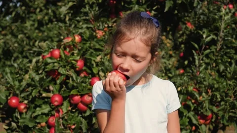 Kid little girl portrait eat bite ripe a... | Stock Video | Pond5