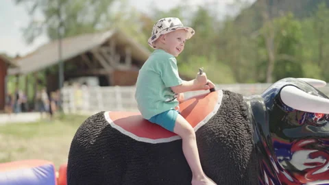 Kid on mechanical bull rodeo riding at w... | Stock Video | Pond5