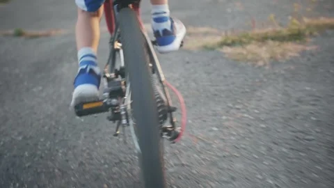 The kid is riding a bike at sunset in pa... | Stock Video | Pond5