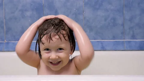 Kid splashing water in bath room. Little... | Stock Video | Pond5