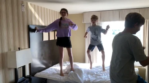 Kids dancing on beds in hotel room laugh... | Stock Video | Pond5