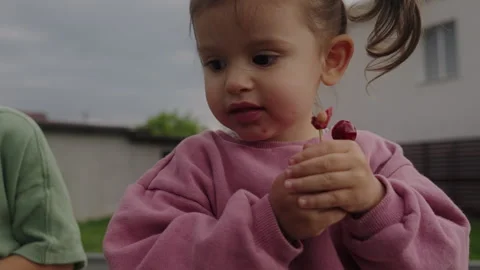 Kids eating cherry from garden trees. Gi... | Stock Video | Pond5