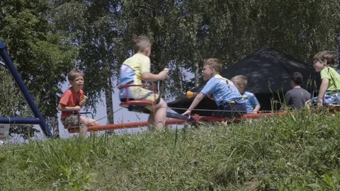 Kids having fun on roundabout playground | Stock Video | Pond5