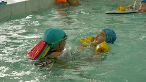 Kids learning to swim in swimming pool ... | Stock Video | Pond5