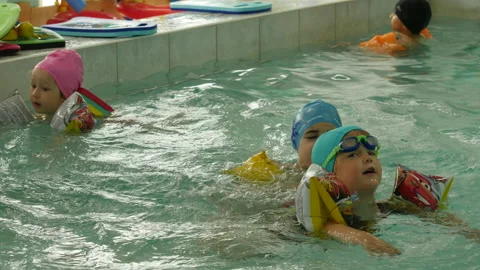 Kids learning to swim in swimming pool ... | Stock Video | Pond5