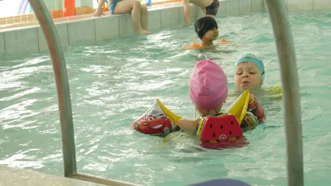 Kids learning to swim in swimming pool ... | Stock Video | Pond5