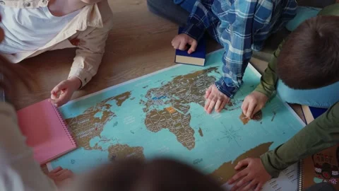 Kids mark points on world map with coin ... | Stock Video | Pond5