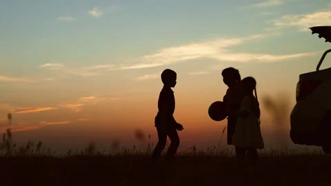 Kids playing at sunset by car, silhouett... | Stock Video | Pond5