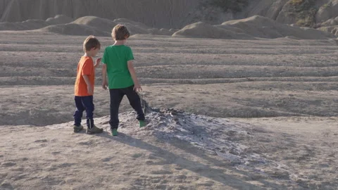 Kids playing by throwing rocks in the mu... | Stock Video | Pond5
