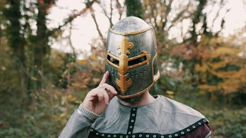 Knight lifting his visor in a forest | Stock Video | Pond5