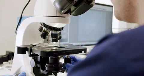 Lab worker is regulating a microscope du... | Stock Video | Pond5