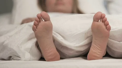 Lady feet in bed itching discomfort, fun... | Stock Video | Pond5